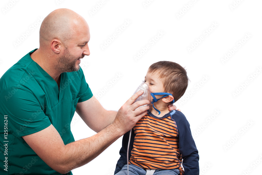 Medical doctor hold a mask inhaler on a little boy. Treatment of asthma ...