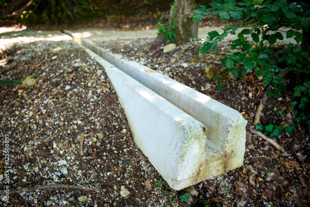 Concrete storm rain drainage on a footpath in the forest. Stock Photo ...