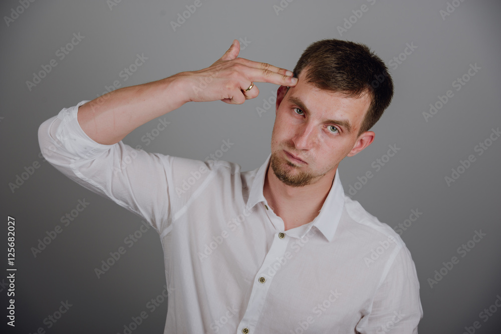 young man pointing finger gun gesture to head Stock Photo | Adobe Stock