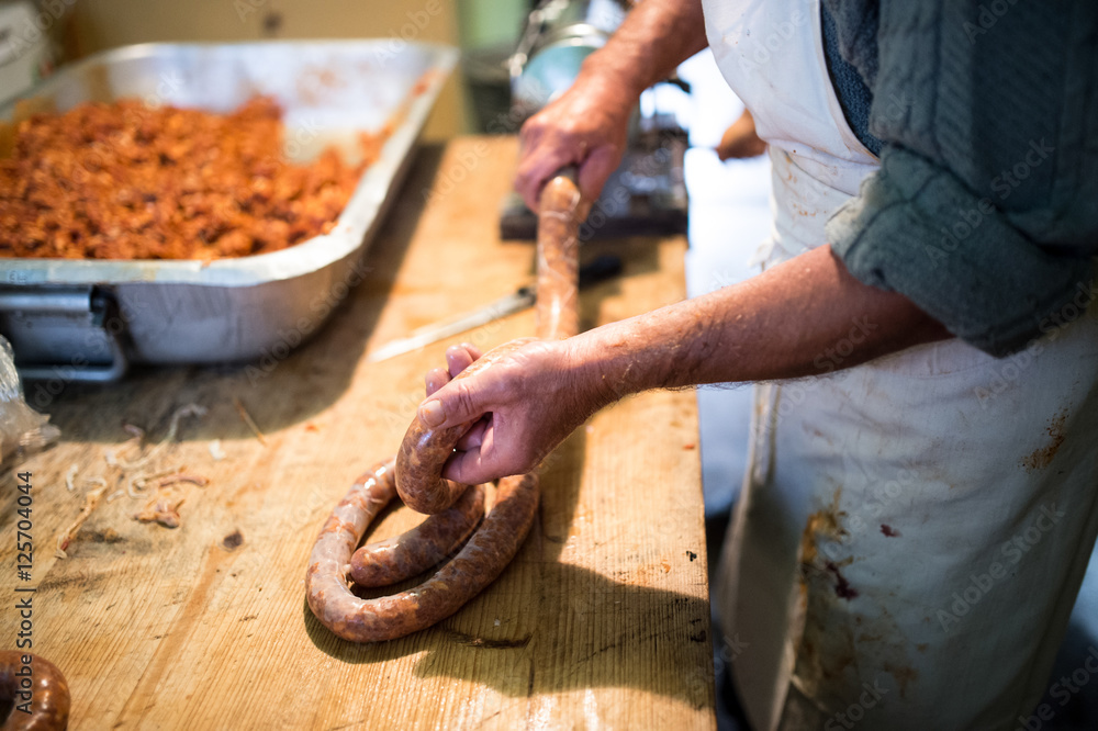 Man making sausages the traditional way using sausage filler. Stock ...