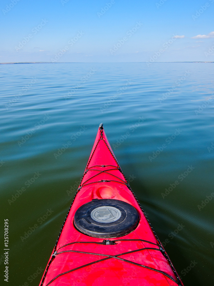 Nose red kayak on the background of calm green water. View from above ...