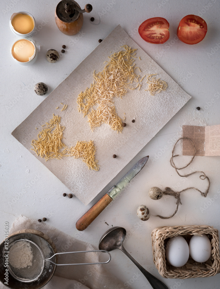 map of the world pasta on the canvas. flour sieve spices. food, top ...