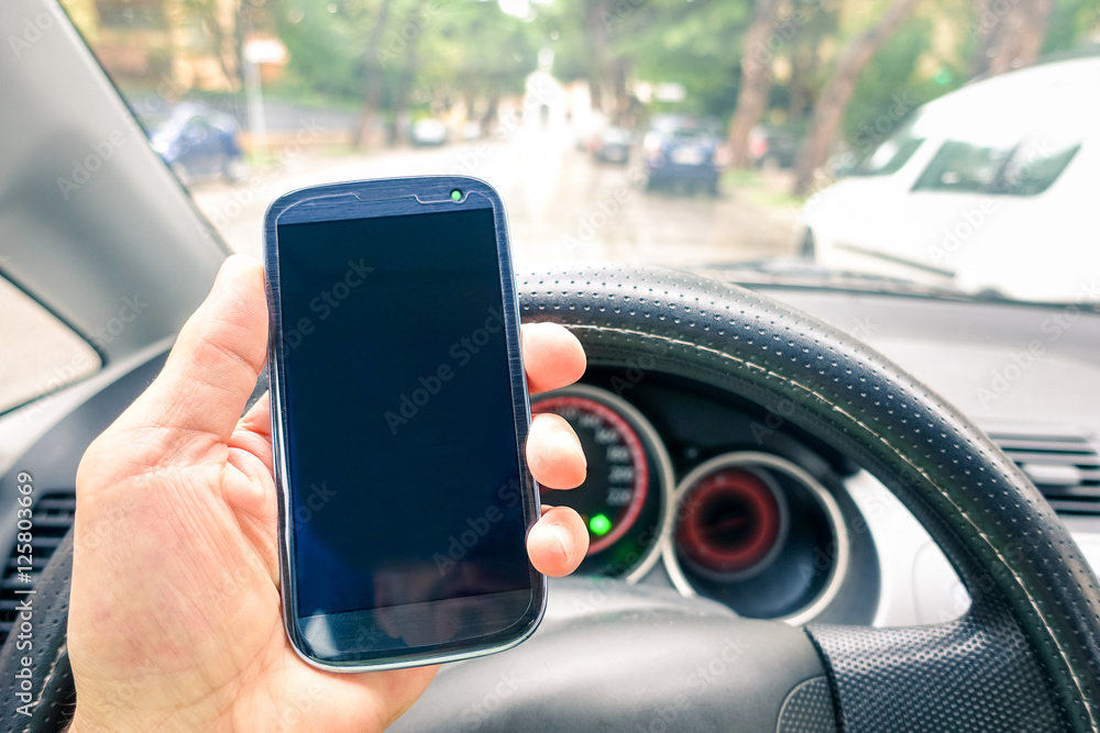 Driver hand holding mobile phone inside car on the road - Close up of ...