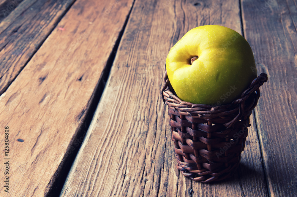 Green apple in small wicker basket Stock Photo | Adobe Stock