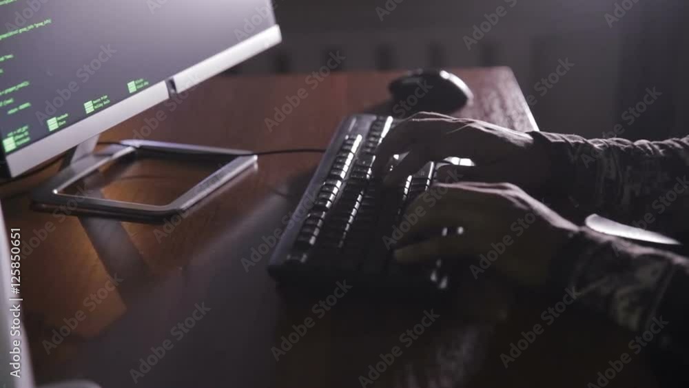 Hacker at night typing on a computer keyboard hacking secret ...
