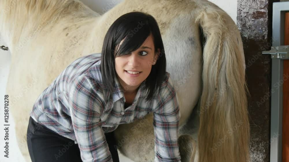 beautiful brunette young woman cleans the horse's hooves Stock Video ...