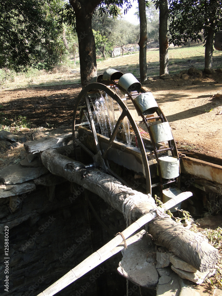 Old fashioned water wheel, draws water from a well Ranakapur, India ...