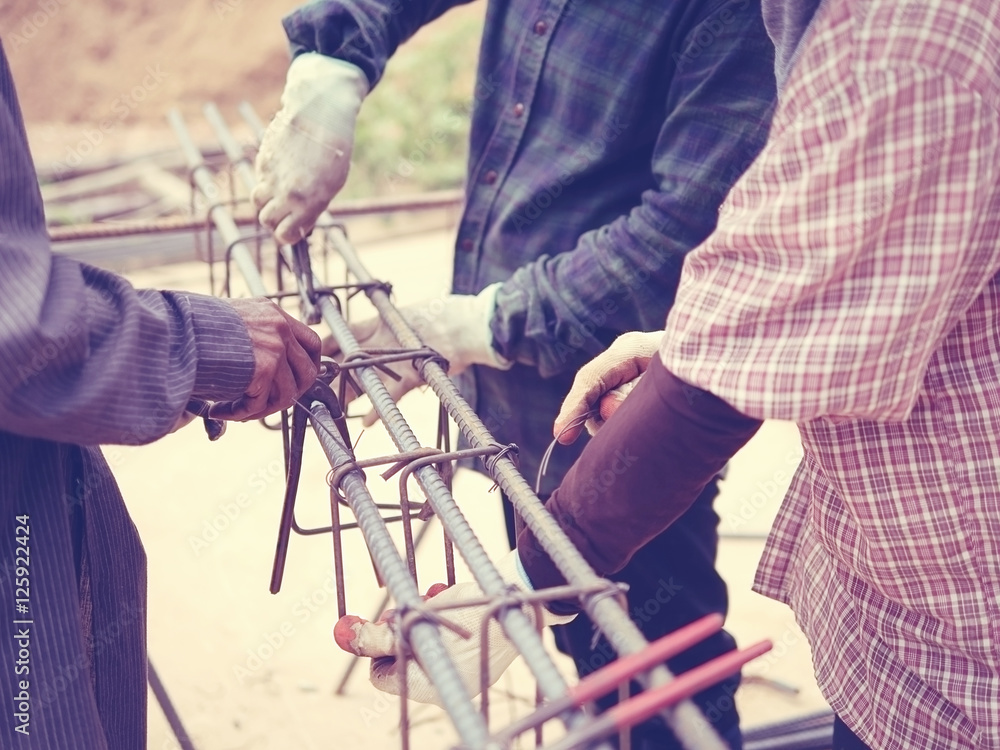 Vintage style photo of construction workers are installing steel rods ...