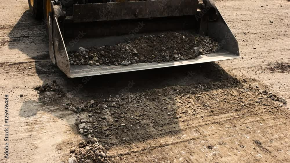 Loader carrying dirt. Workers with shovels. Builders work double shifts ...