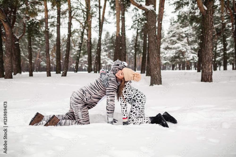 Winter holidays. Happy couple in christmas costumes hugging on the snow ...