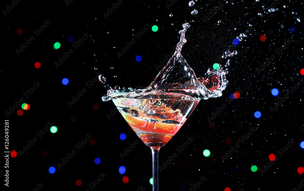 Colorful cocktail with splash on blurred lights background Stock Photo ...