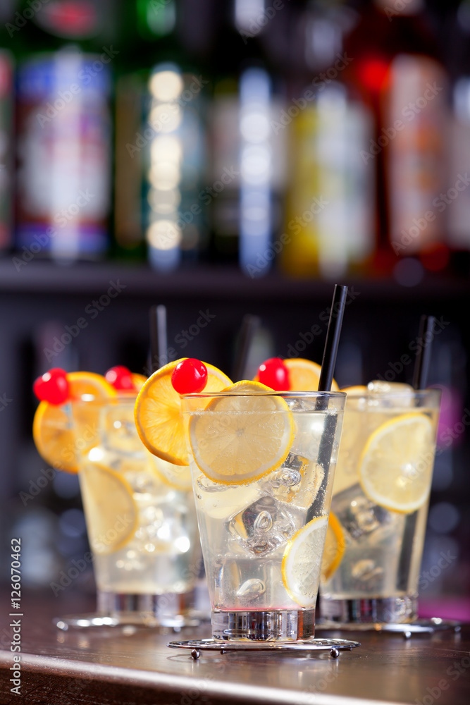 Four Tom Collins cocktails on a bar in a nightclub. Vertical sho Stock ...