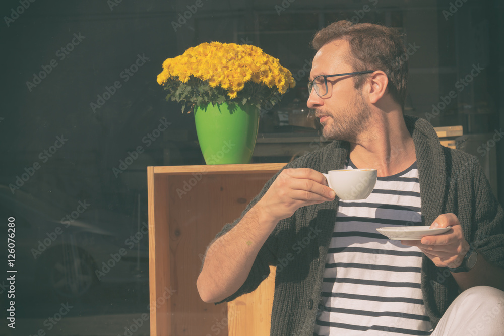 Hipster guy drinking coffee outdoors. Stock Photo | Adobe Stock