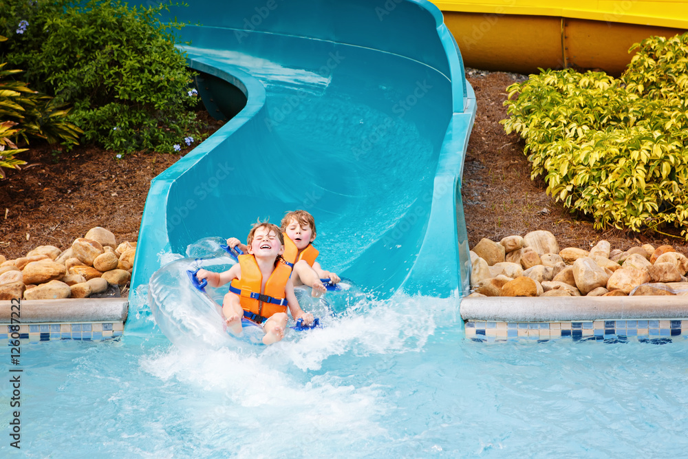 excited children in water park riding on slide with float Stock Photo ...