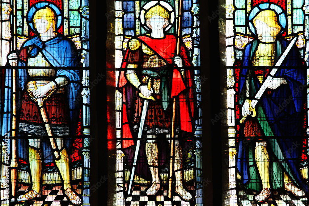 Medieval knight saints on a stained glass window at St Peter's Church ...