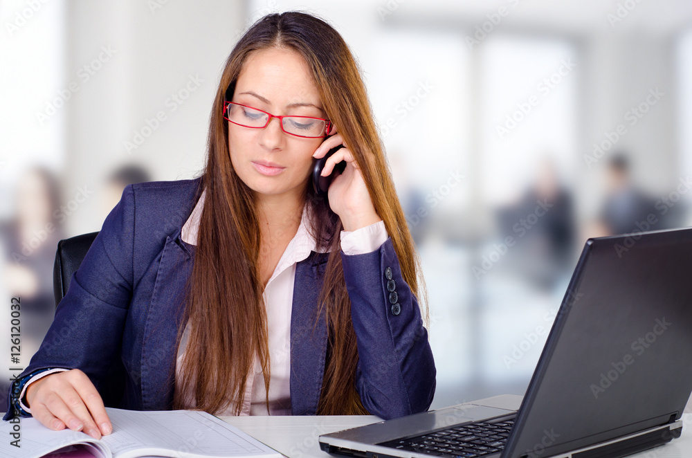 Beautiful young business woman making a phone call from her office ...