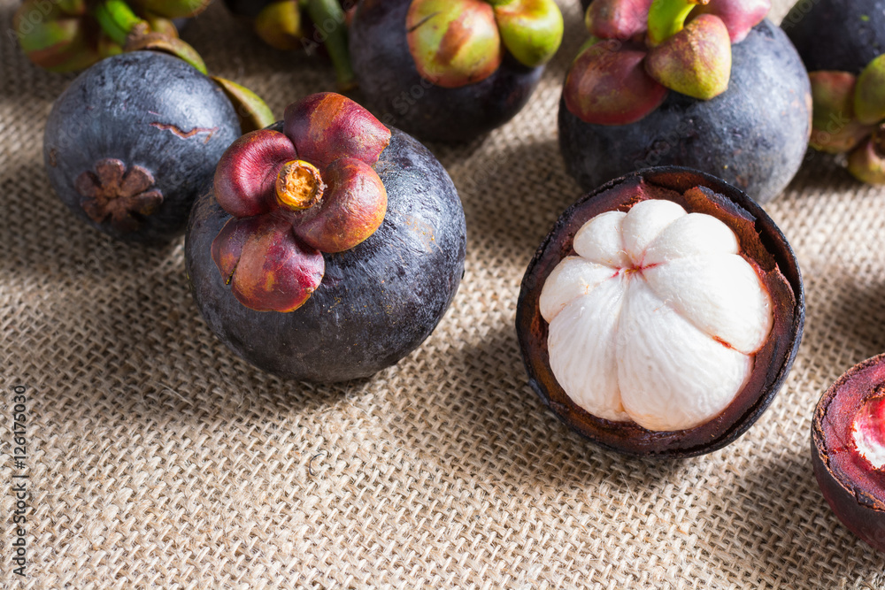 Mangosteen and cross section showing the thick purple skin and w Stock ...