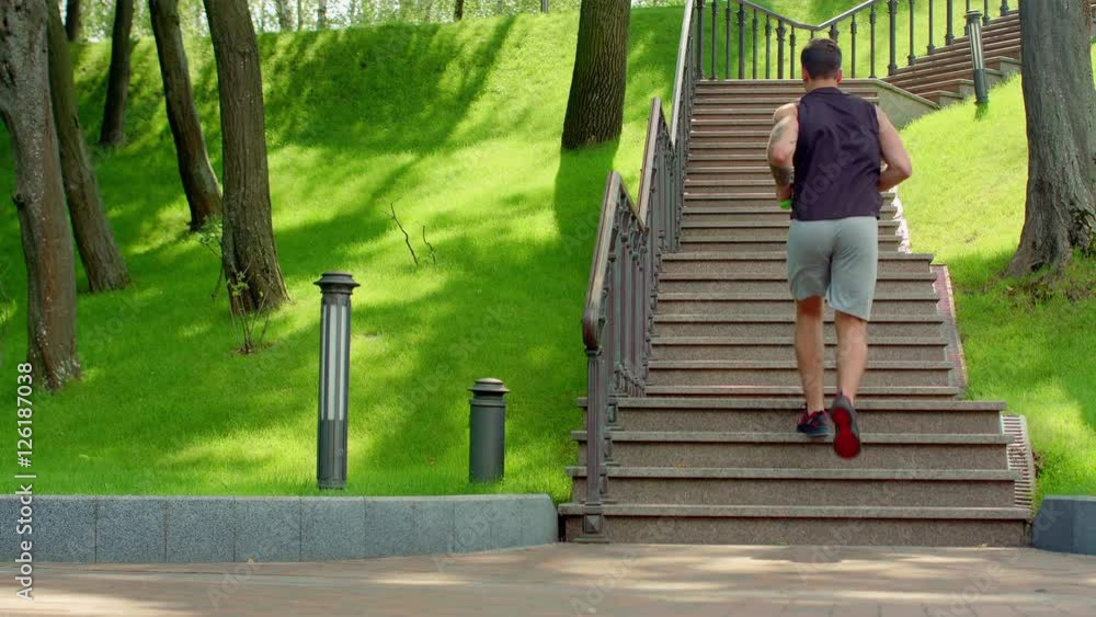 Fitness man run up stairs in slow motion. Young man running upstairs ...