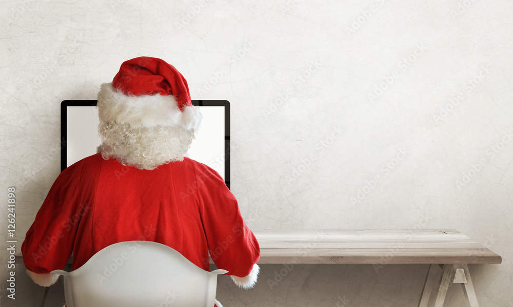 Santa Claus responds to letter of wishes on a computer. Front view of ...