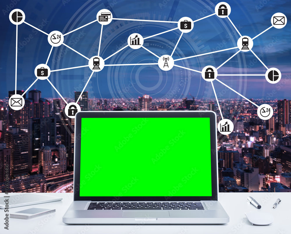Blank green screen laptop computer with night cityscape and digital ...