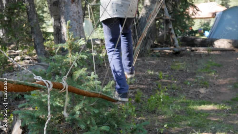 Gimbal shot of scouts on rope monkey bridge at camp Stock Video | Adobe ...