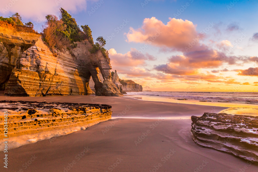 Sunset on a rocky beach in Taranaki district, New Zealand Stock Photo ...
