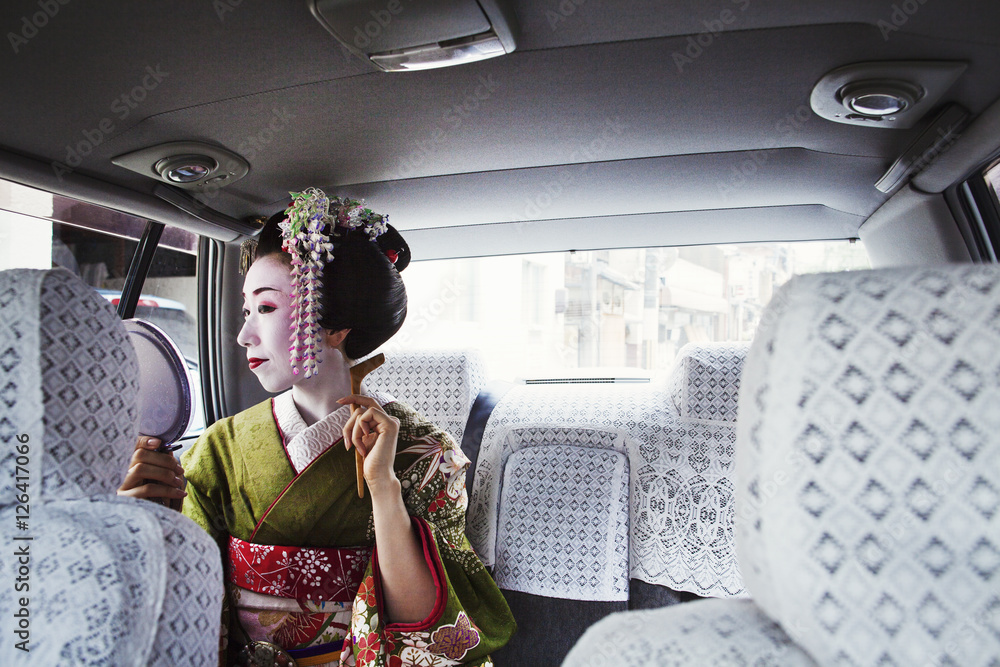 A woman dressed in the traditional geisha style, wearing a kimono with ...