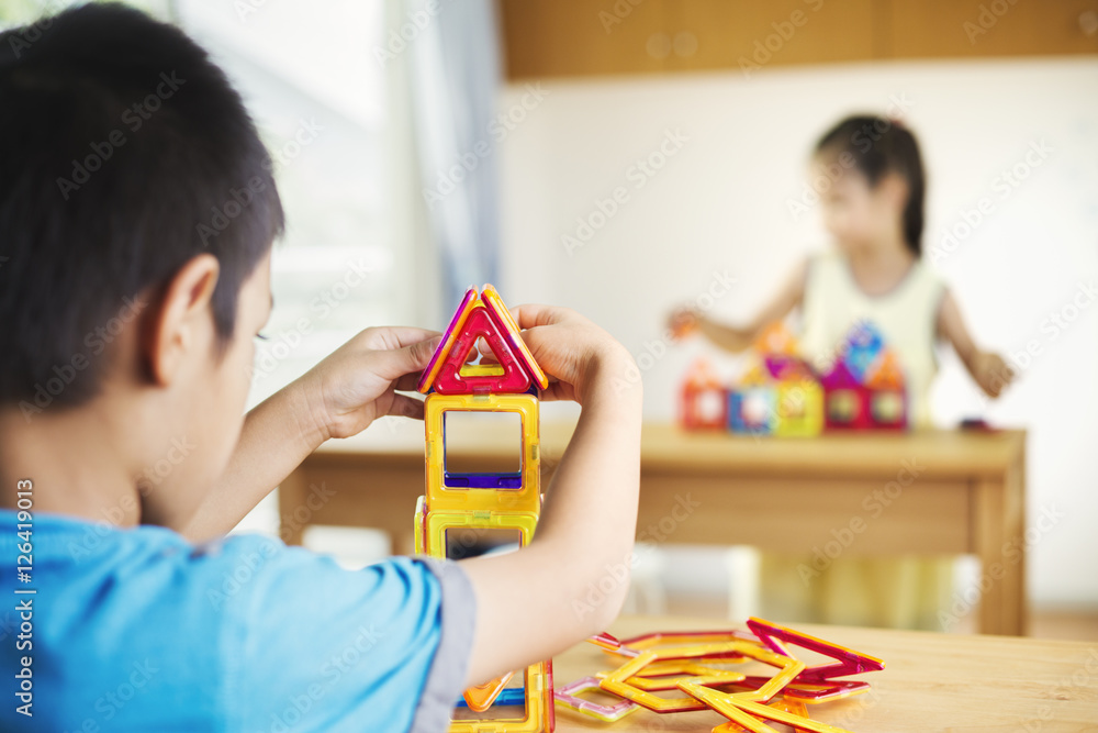 Two children building using geometric shapes. Stock Photo | Adobe Stock