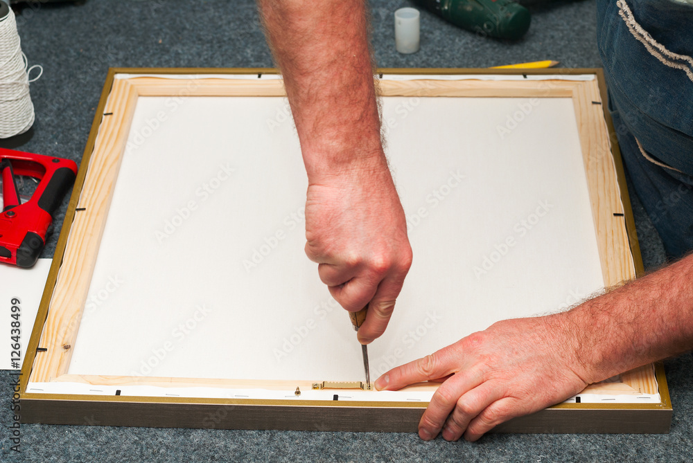 Craftsman working on frame in frame shop. Professional framer hand ...