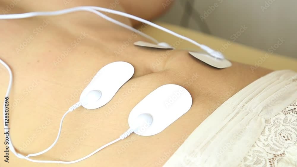 professional electrotherapy on woman body. muscle contraction under the ...
