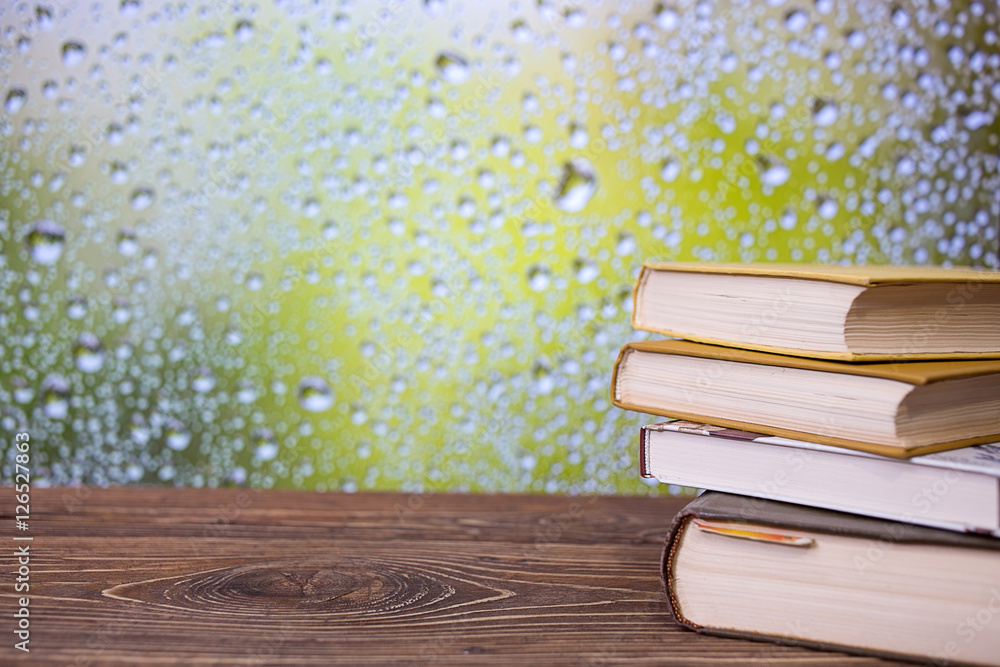 Books on an retro wooden table on a rainy day window background Stock ...