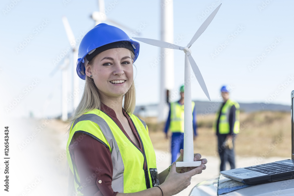 Female engineer working on site, holding model of wind turbine Stock ...