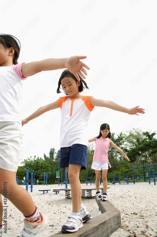Girls walking on balance beams, arms outstretched Stock Photo | Adobe Stock