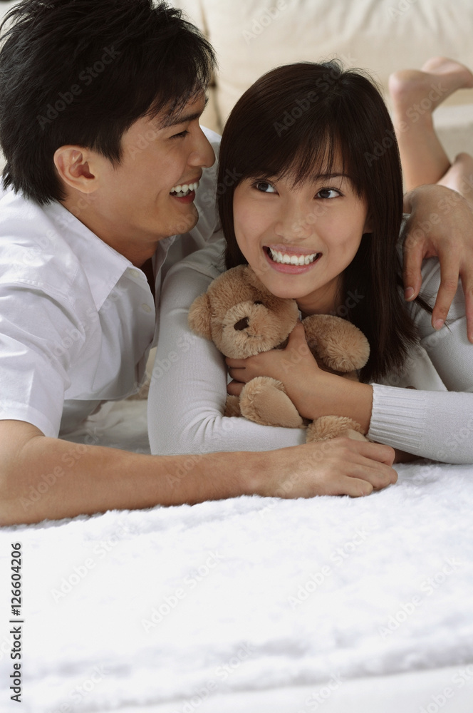 Young couple laughing while hugging and lying on the floor Stock Photo ...