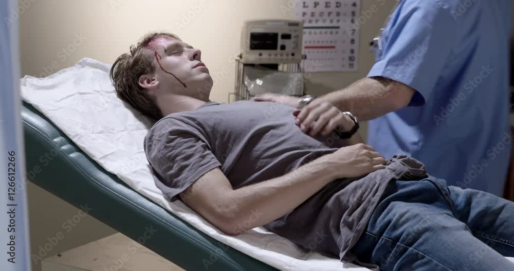 Male nurse enters examination room in hospital casualty department to ...