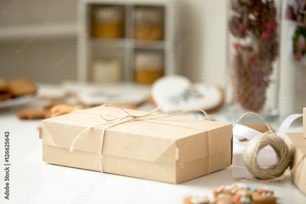Cardboard box, postal parcel wrapped in brown kraft paper tied with a ...