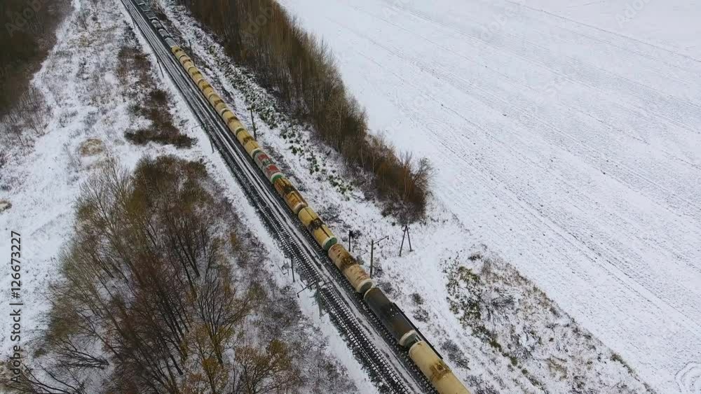 Freight train on the railway in winter. Gasoline, fuel tanks. Aerial ...