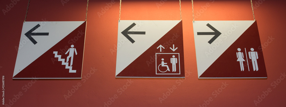 Public restroom signs with arrow on orange background Stock Photo ...