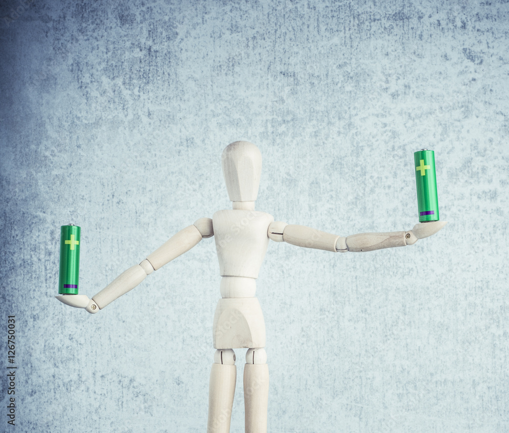 Concept of green energy and power with wooden figure holding aa ...