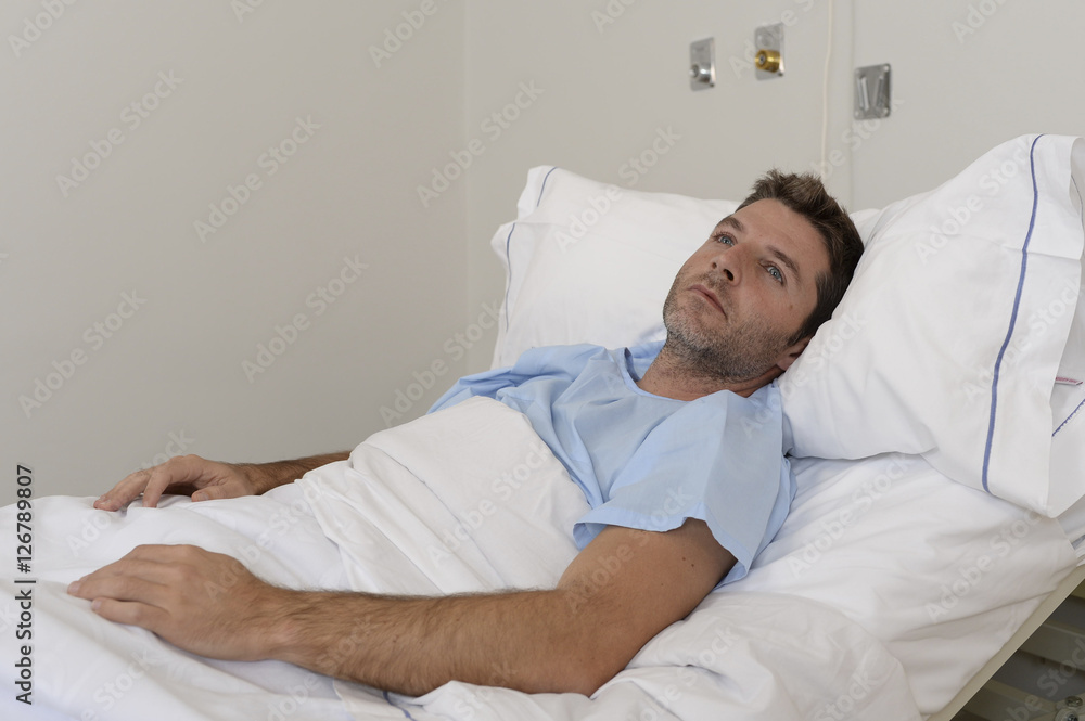 young patient man lying at hospital bed resting tired looking sad and ...