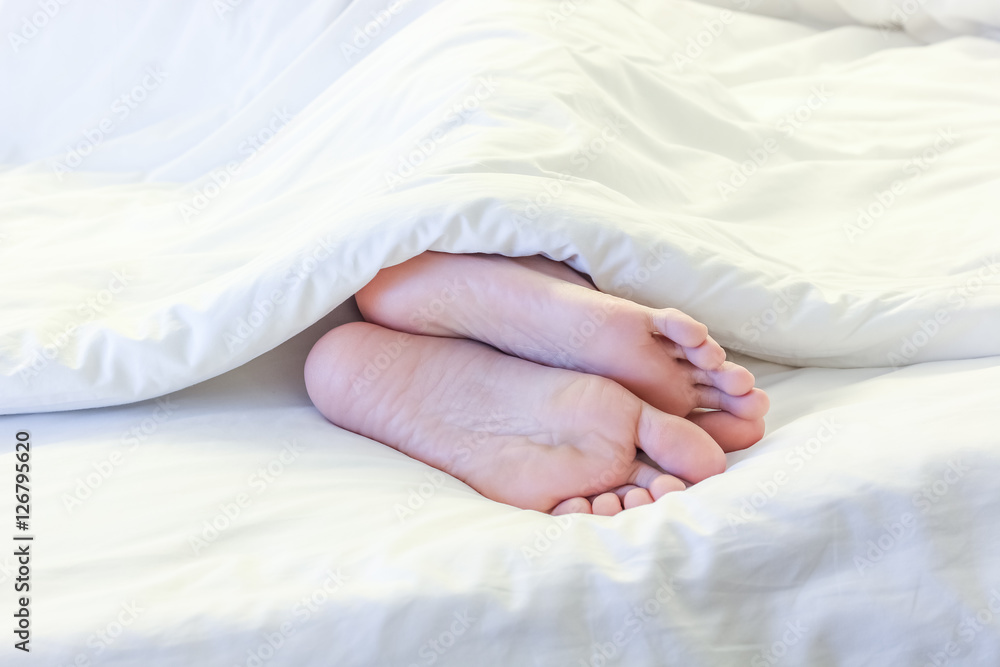 Feet of sleeping woman in white bed room Stock Photo | Adobe Stock