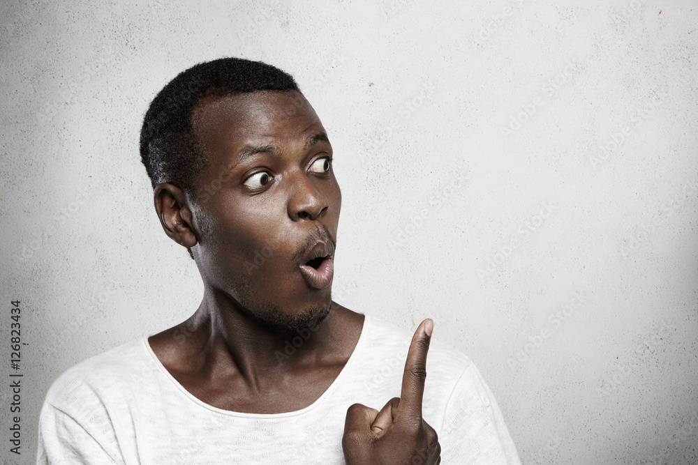 Studio portrait of bug-eyed dark-skinned man with amazed and astonished ...