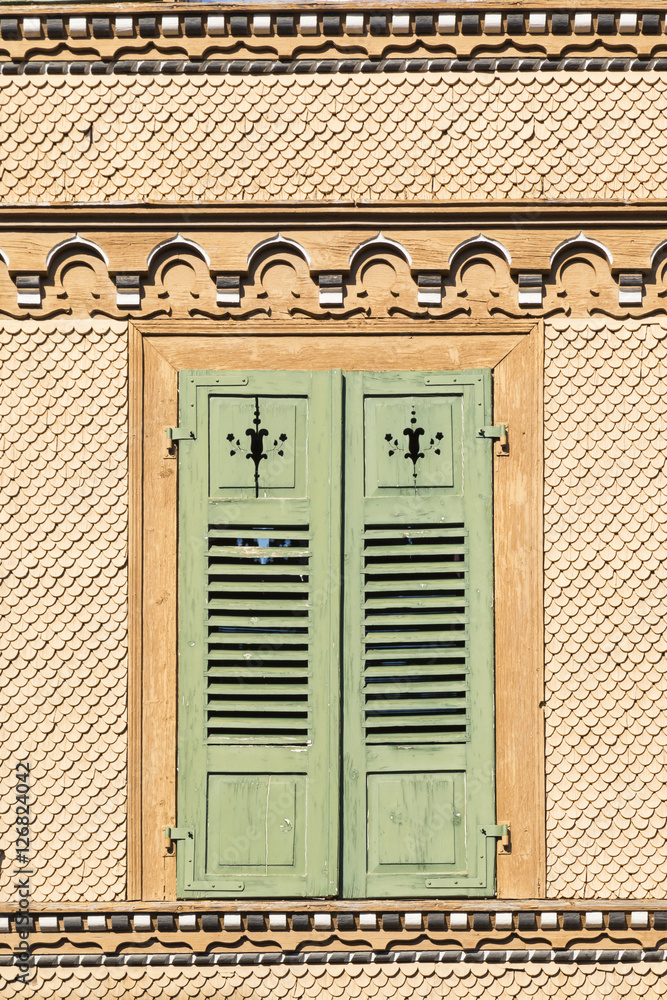 Detail of an old swiss chalet with shingles and green painted withered ...
