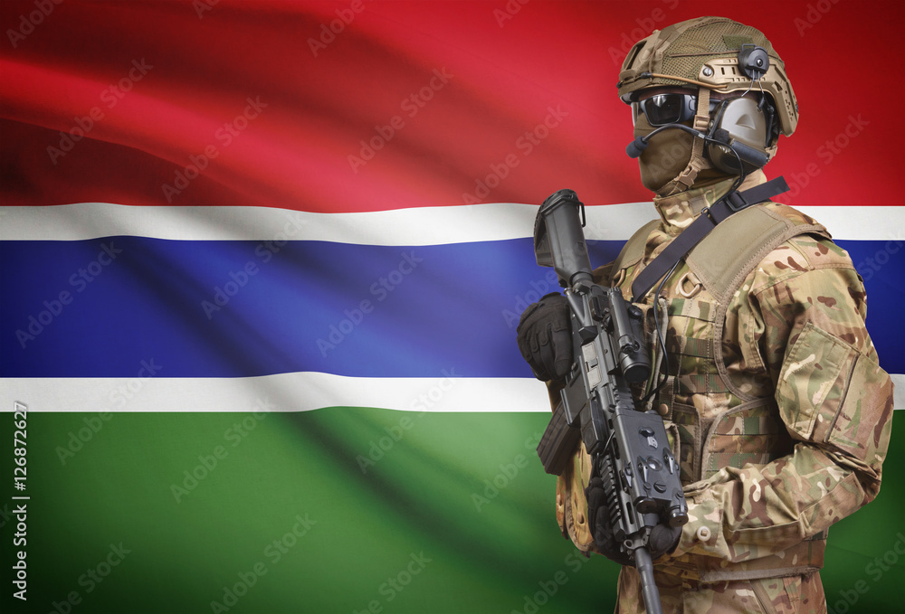 Soldier in helmet holding machine gun with flag on background series ...