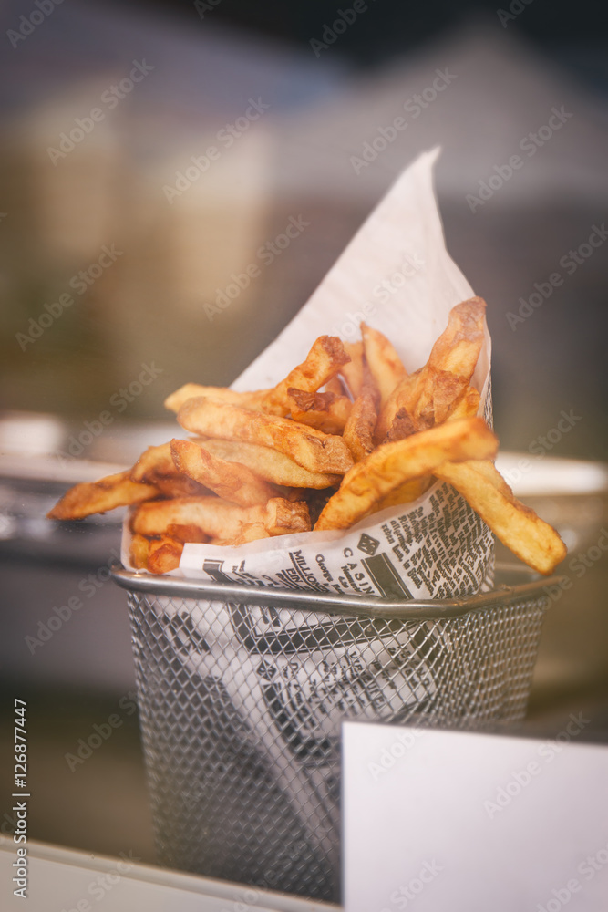 Pommes frites or french fries behind the counter window, ready to eat ...