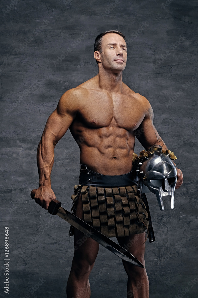 Middle age, muscular male holds silver gladiator helmet and an i Stock ...