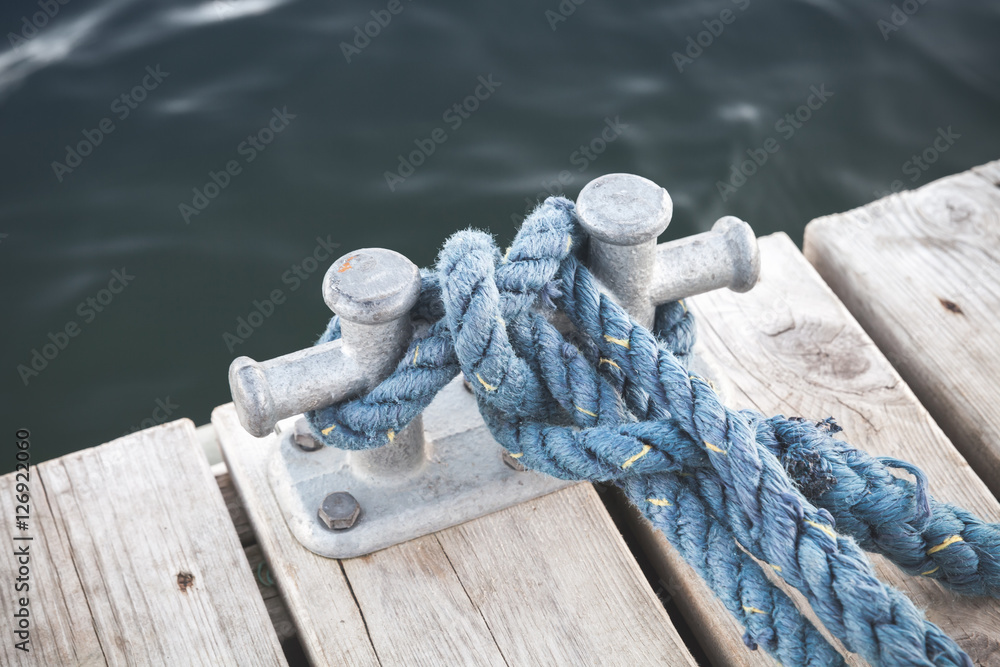 Mooring bollard with tied blue rope Stock Photo | Adobe Stock