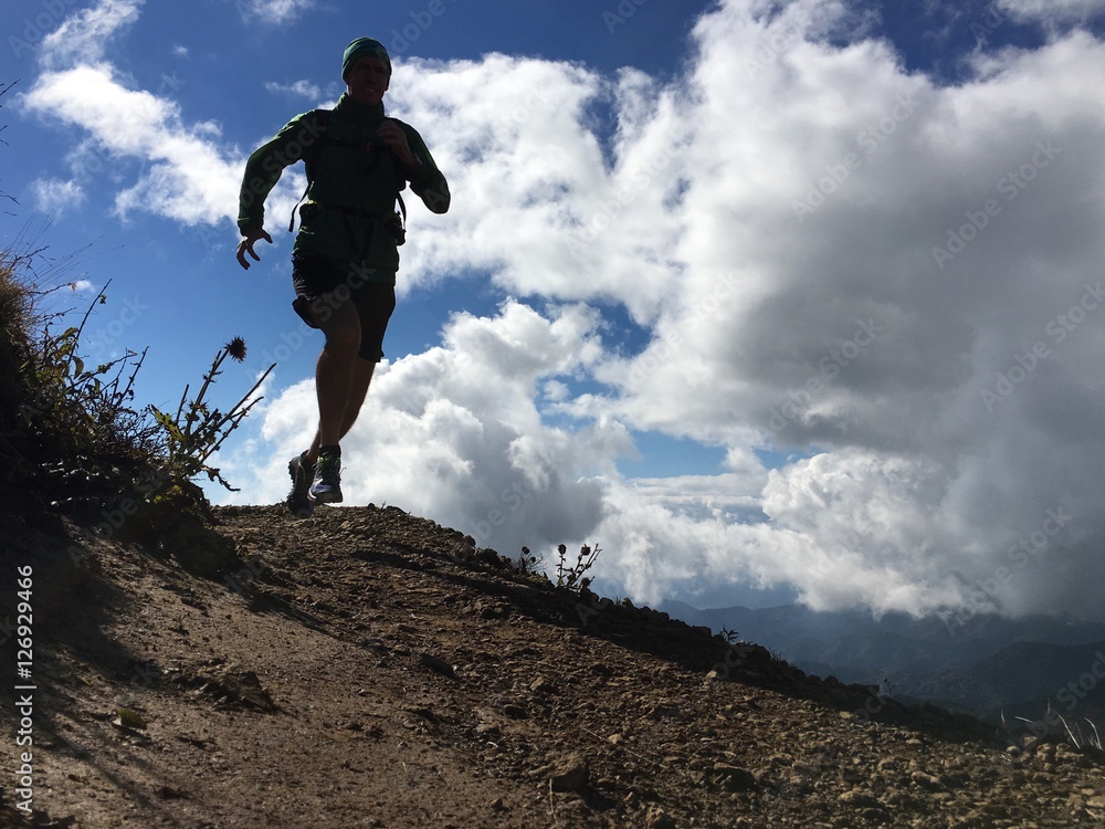 Backlit shot of male runner on mountian top trail Stock Photo | Adobe Stock
