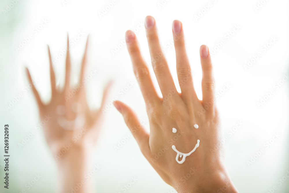 Closeup woman beautiful hands with long fingers applying moisturising ...