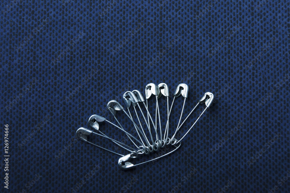 safety pin on blue background Stock Photo | Adobe Stock